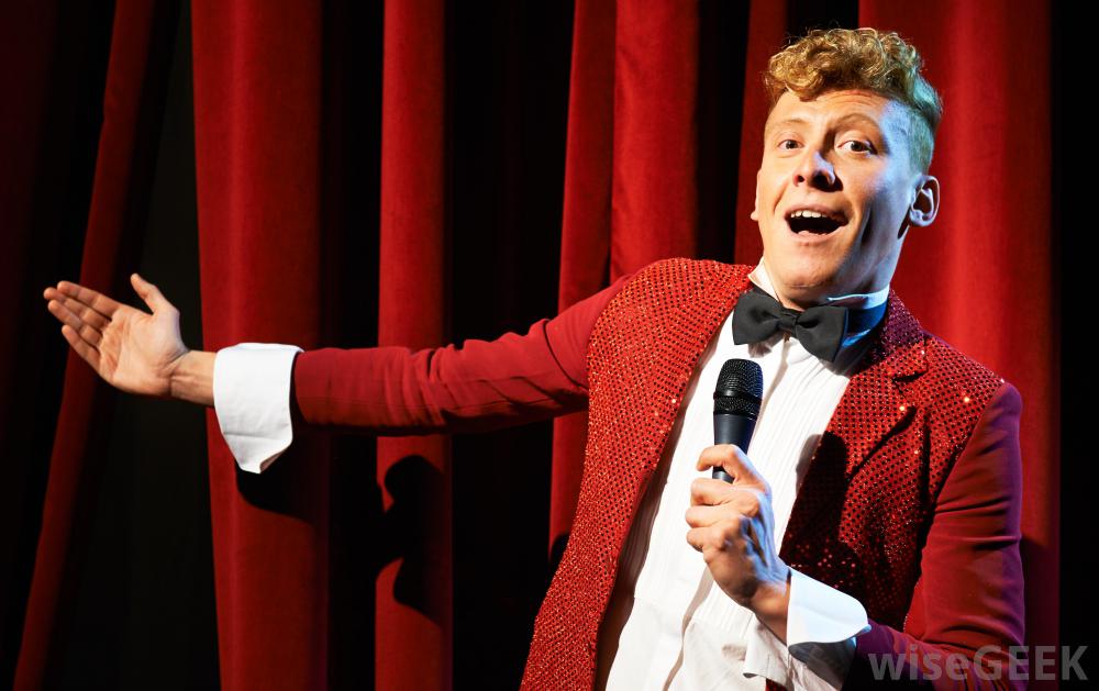 MC man-in-red-jacket-on-stage-with-microphone-near-red-curtain ...